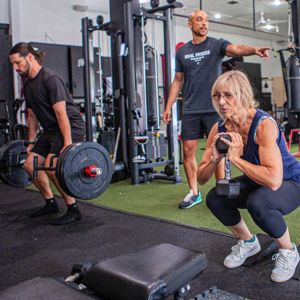 Training Gym with green turf, free weights, squat racks and other ...