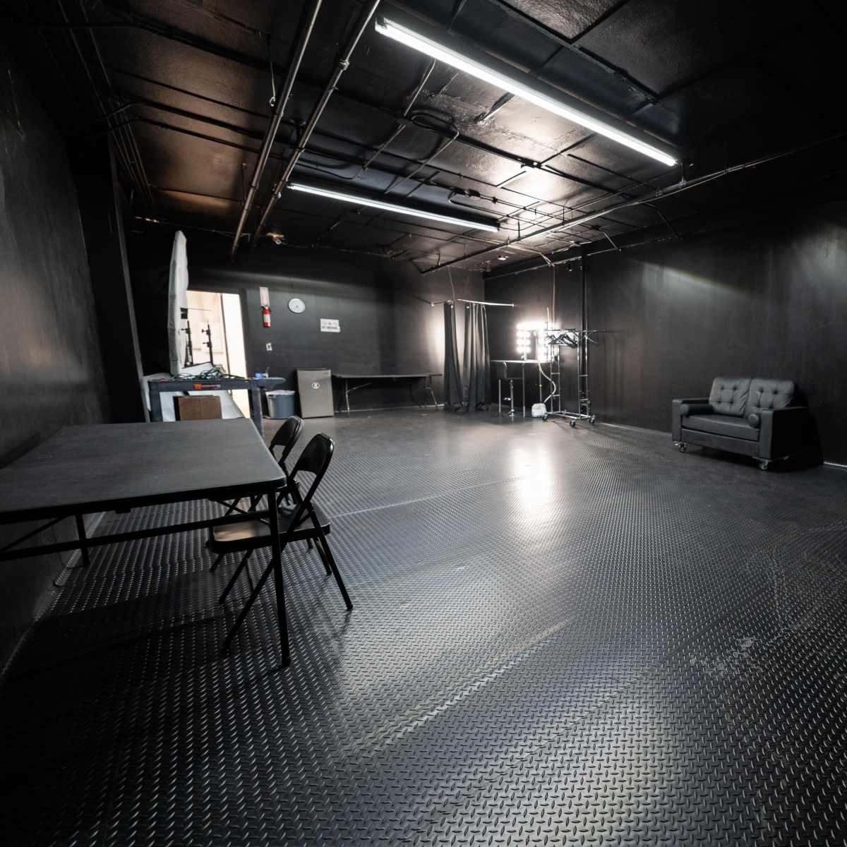 True blackout photo studio with black walls, black ceiling & hardwood ...