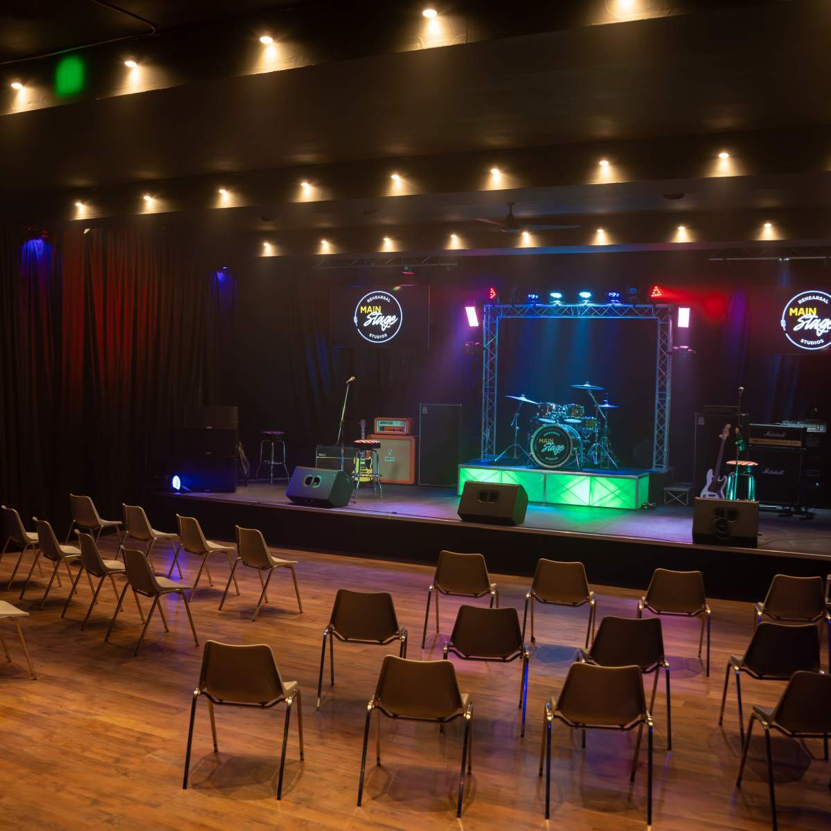 Event venue with elevated stage, full backline and stage lighting ...