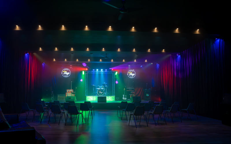 Event venue with elevated stage, full backline and stage lighting ...