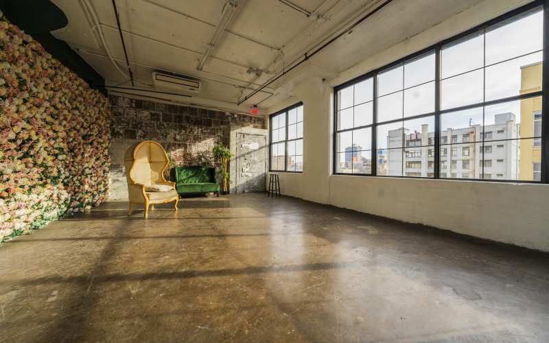 Sunrise studio with Flower wall and Large framed Windows. Exposed block ...