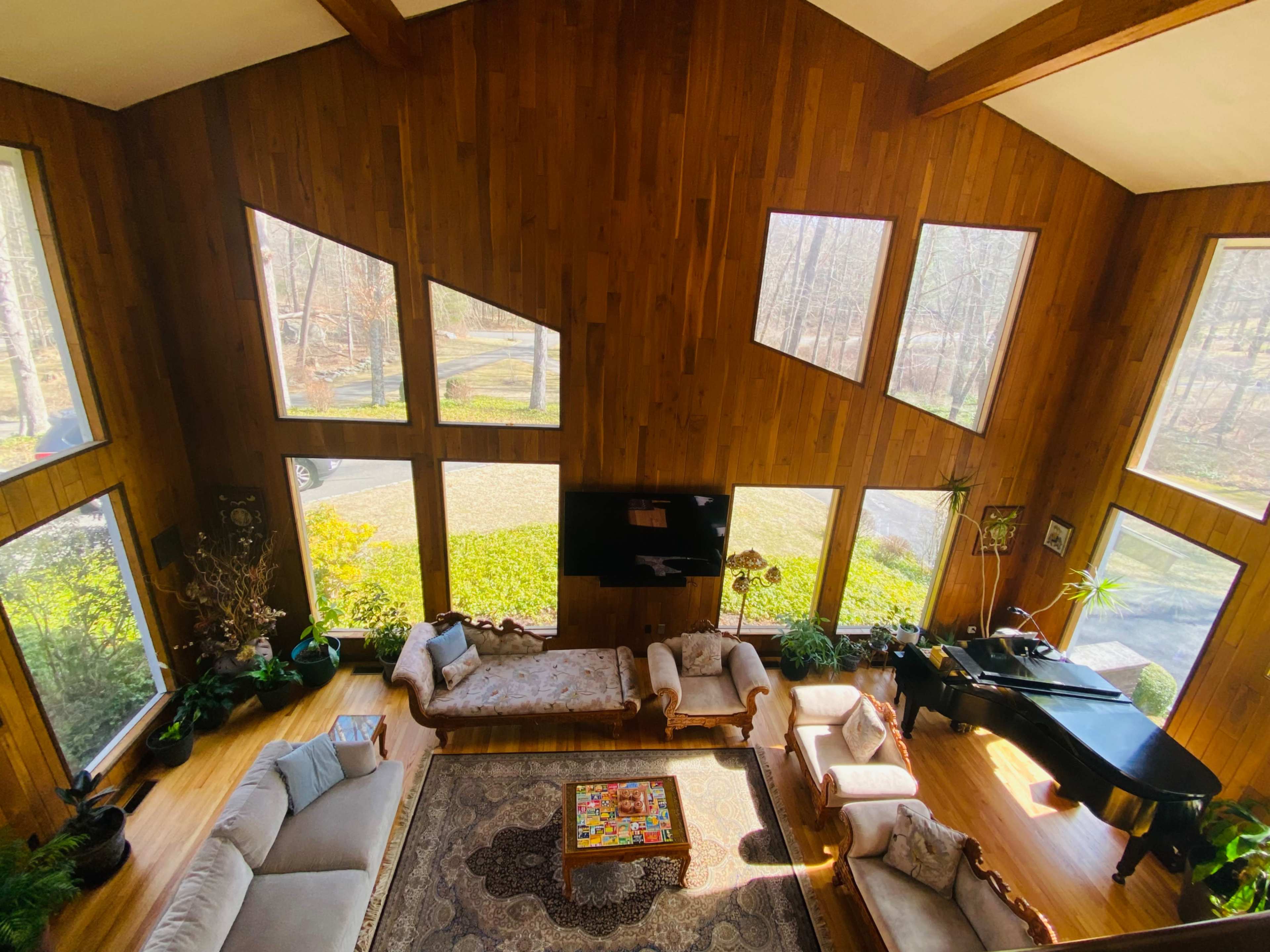 Rich Cedar Paneled Living Room with Expansive Floor to Ceiling Windows ...
